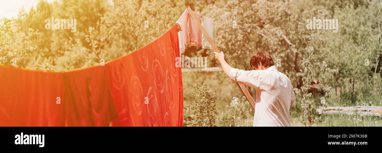 candid young mature choring man chore homework and hanging laundry to ...