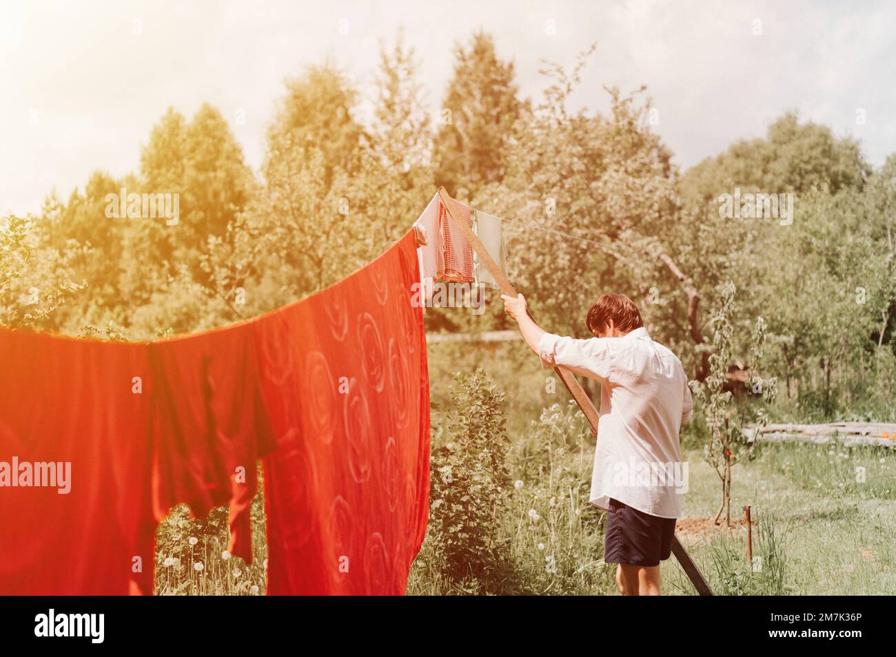 candid young mature choring man chore homework and hanging the laundry ...