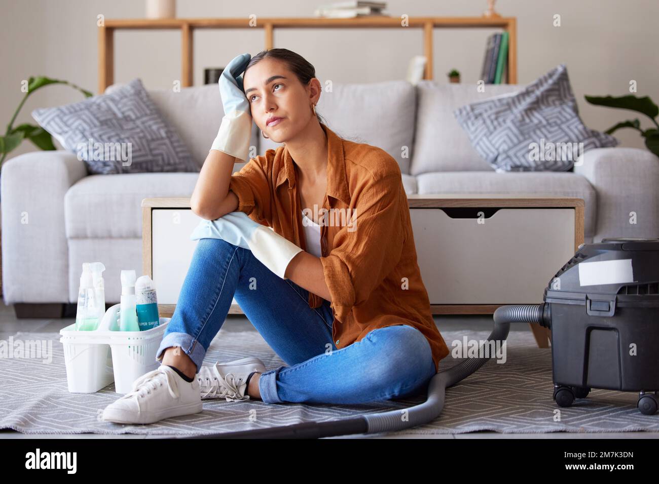 Tired, sad and woman cleaning home overwhelmed, stressed and moody ...