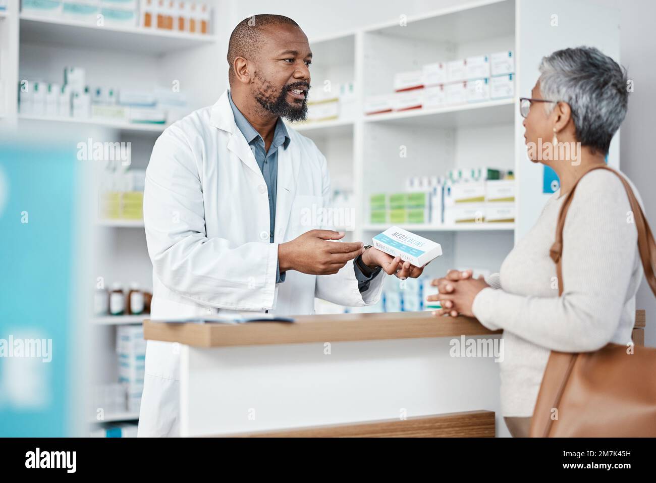 Healthcare, pharmacist and woman at counter with medicine or ...