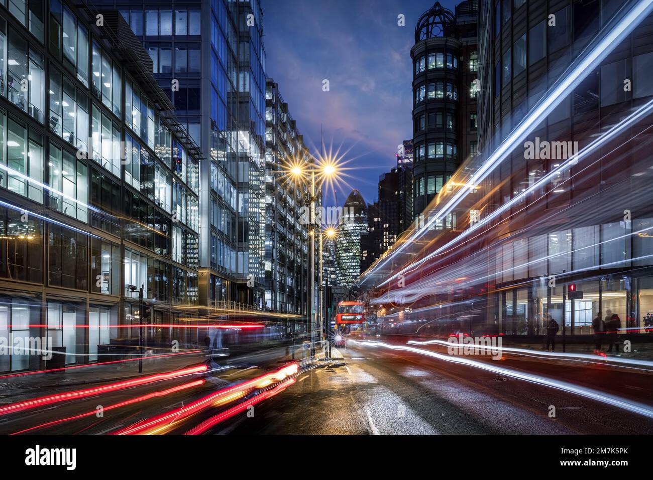Evening view of a busy road in the City of London with traffic light ...