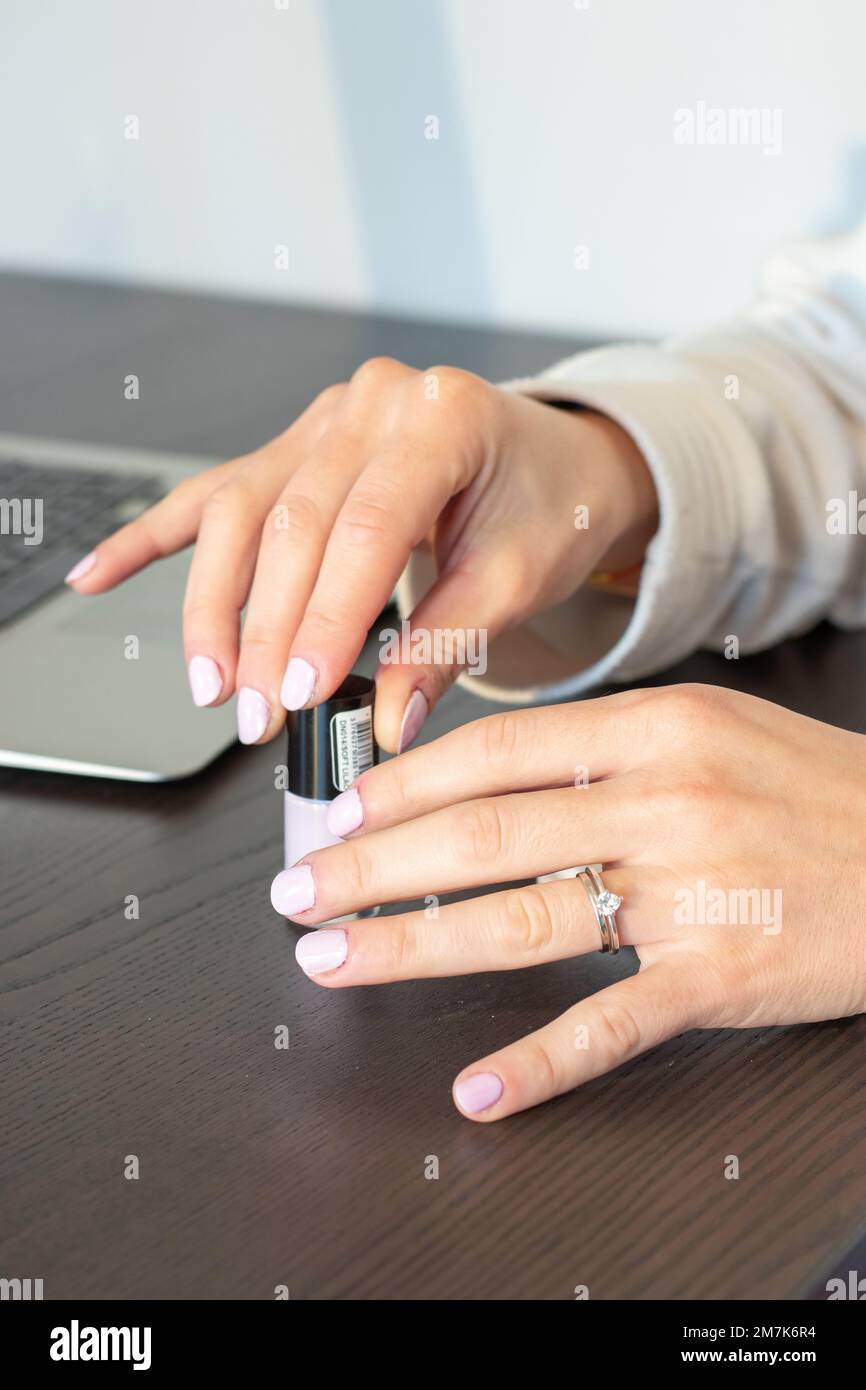 A vertical shot of a woman's hands with a pastel pink nail polish Stock ...