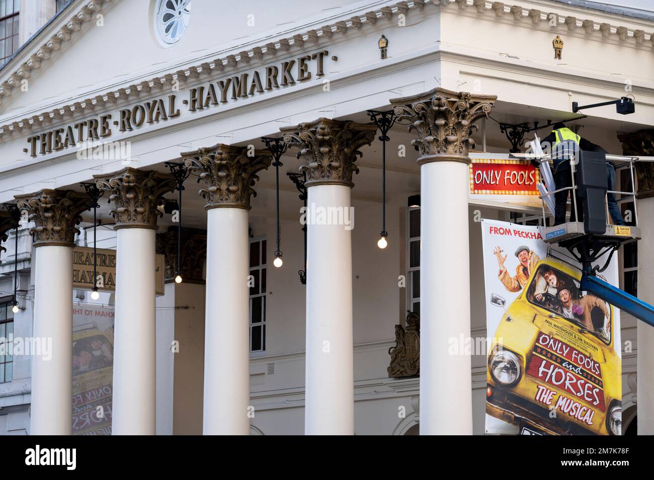 Contractors work on placing new banners to the exterior of the Theatre ...