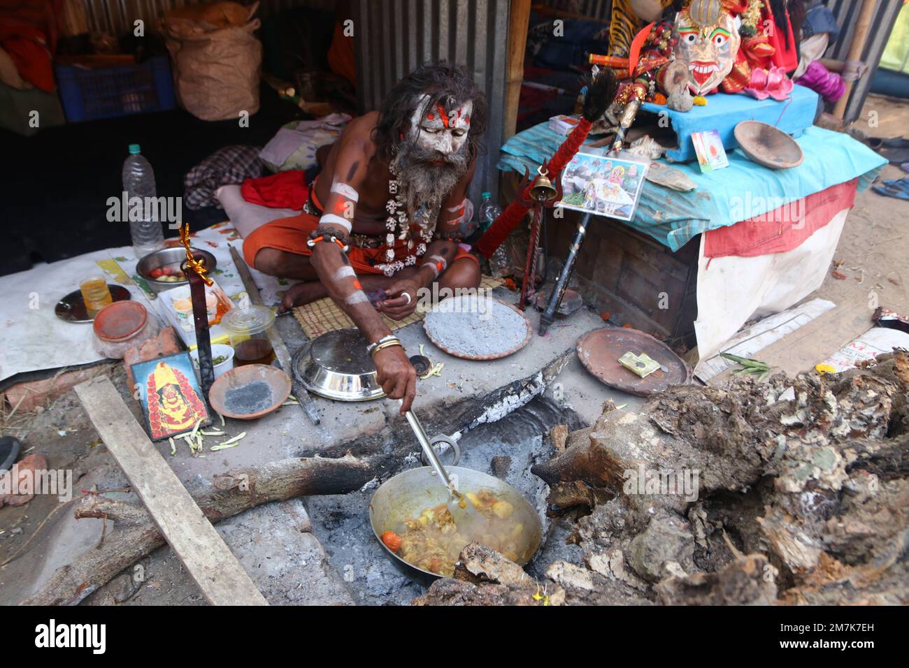 Naga Sadhu or a Hindu holy man busy cooking and preparing lunch in a ...