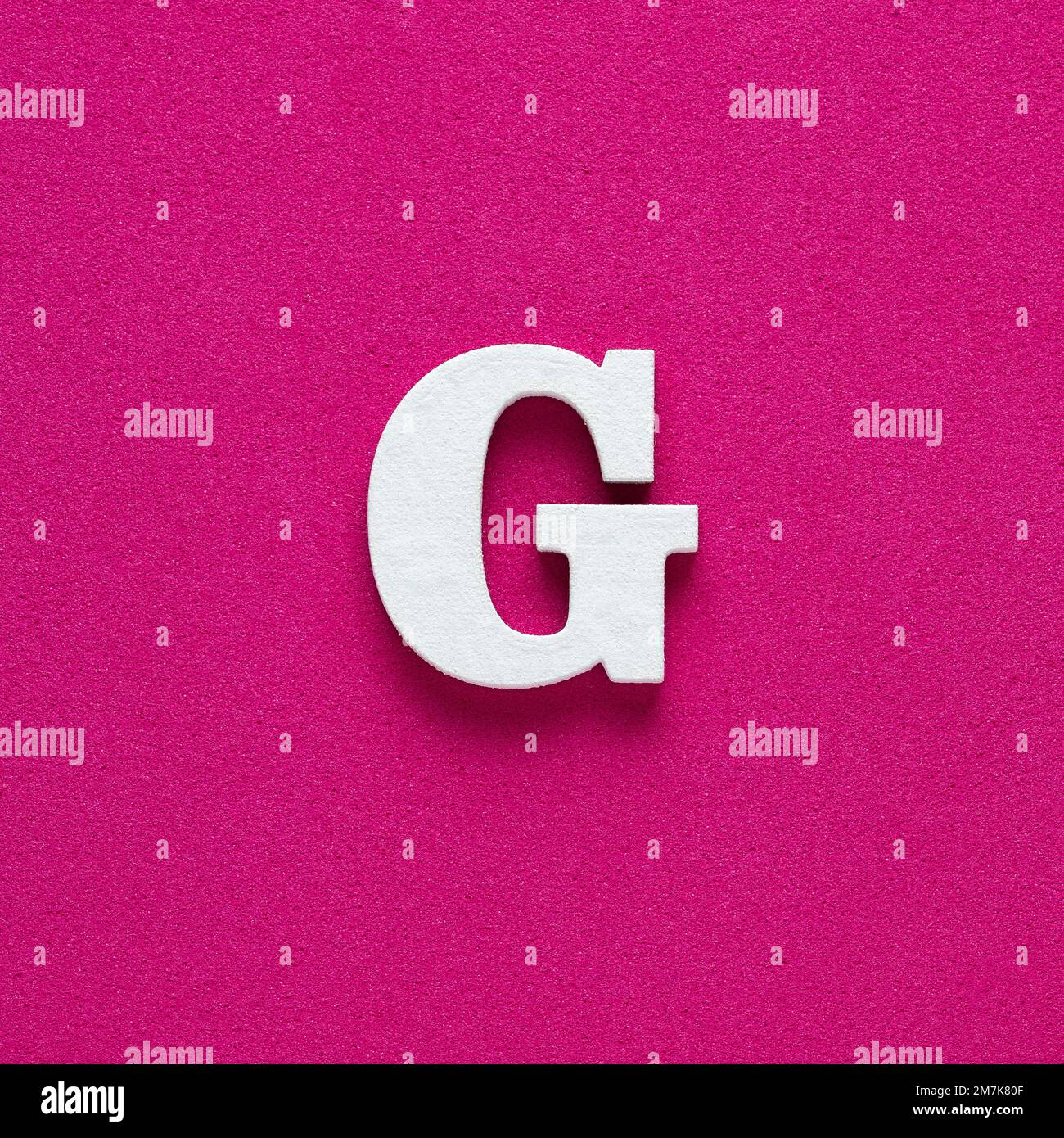 Alphabet letter G - White wooden letter on rhodamine red background ...