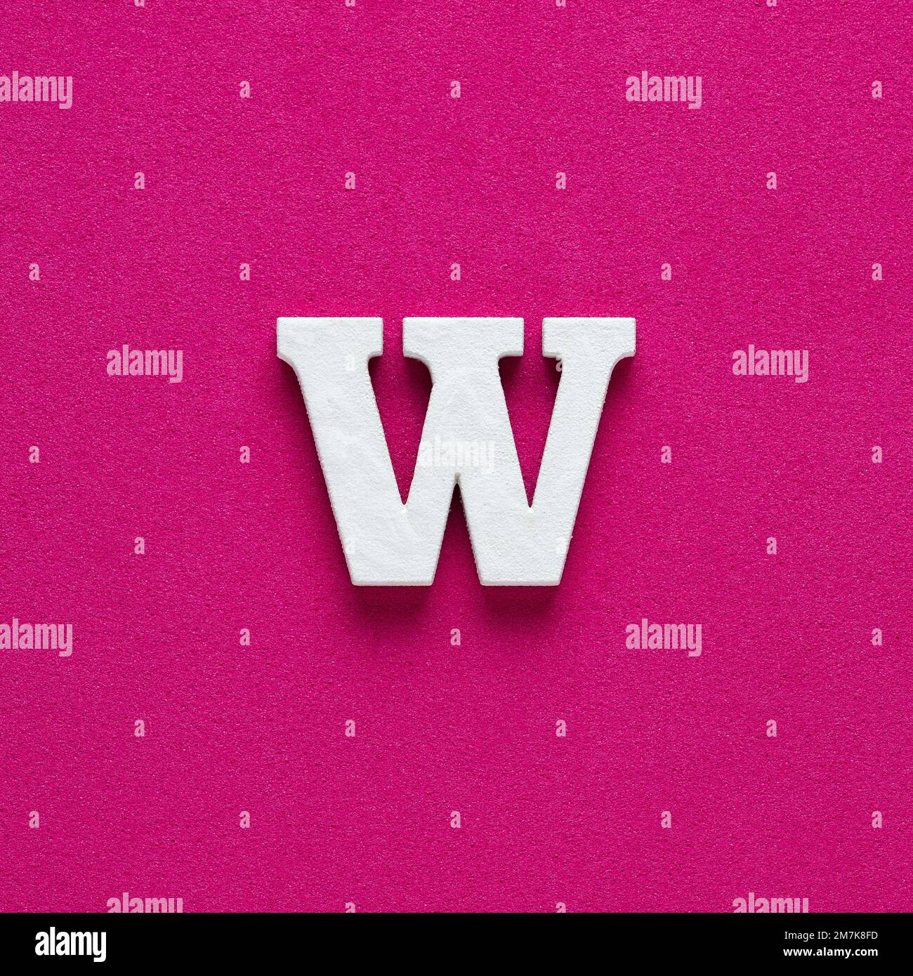 Alphabet letter W - White wooden letter on rhodamine red background ...