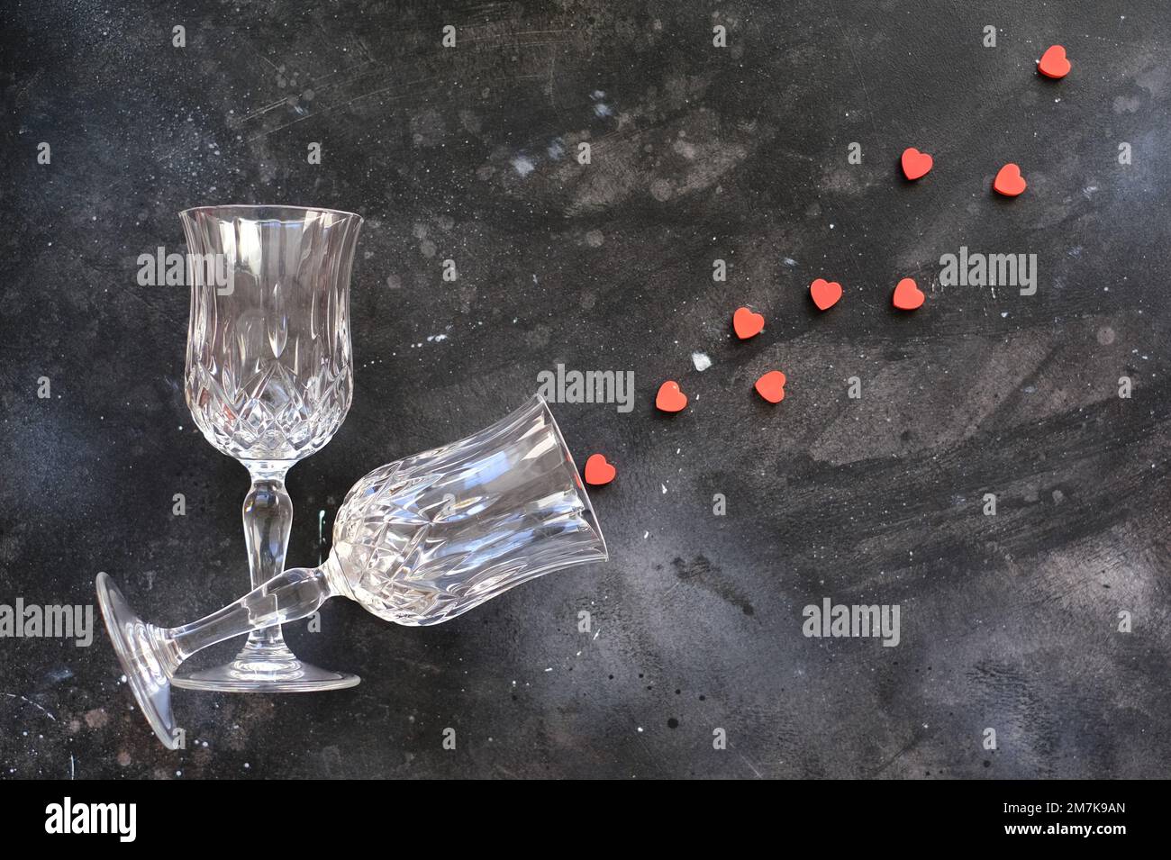 Two glasses with red small hearts on dark background Stock Photo - Alamy