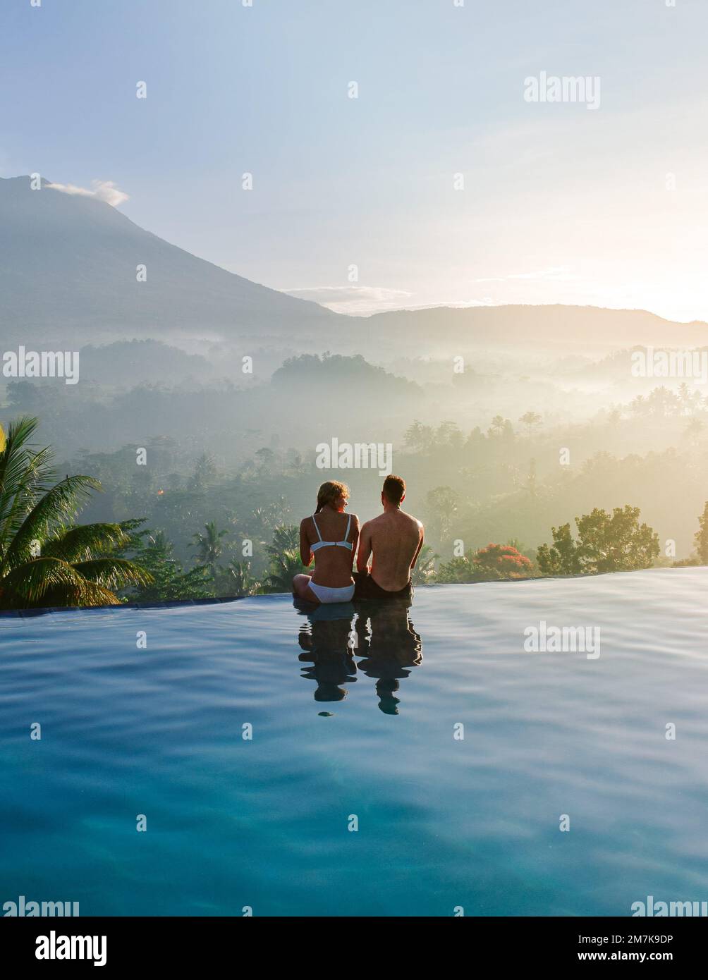 Young couple watching charming mountain views from a water pool villa ...