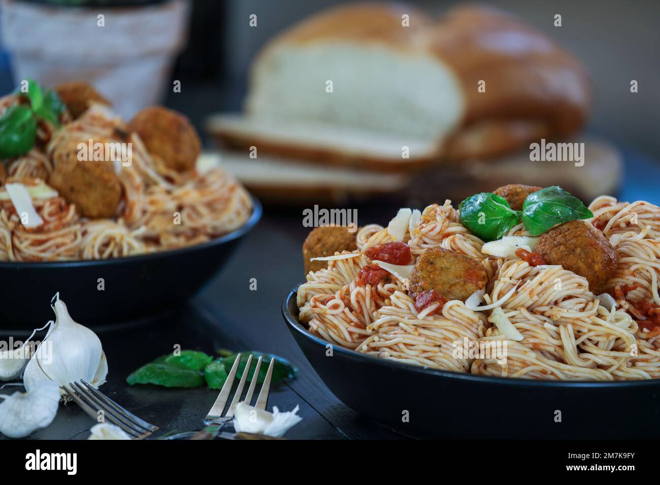 Selective focus of two plates of spaghetti and meatballs pasta with ...