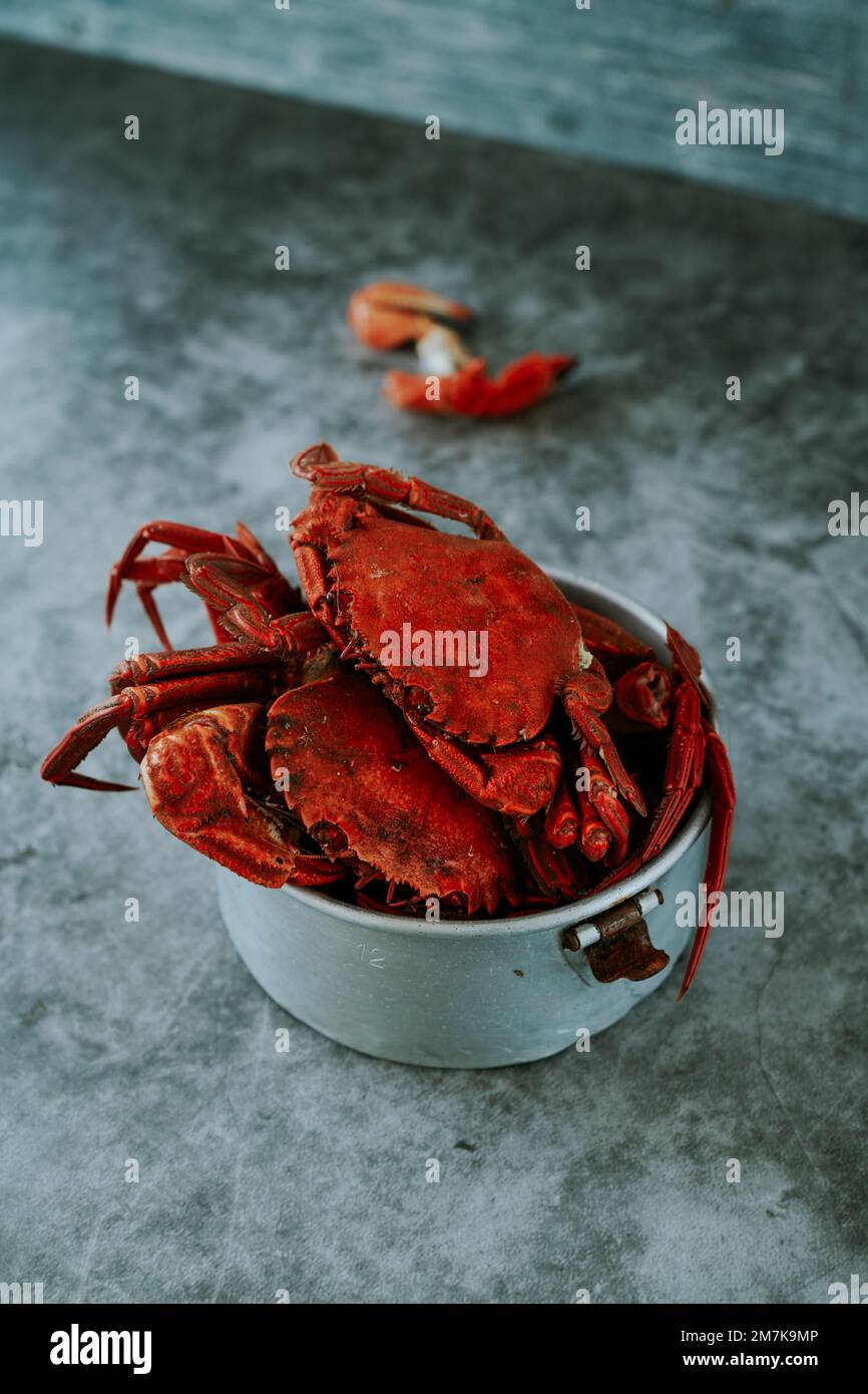 some cooked velvet crabs in an aged aluminum container, placed on a ...