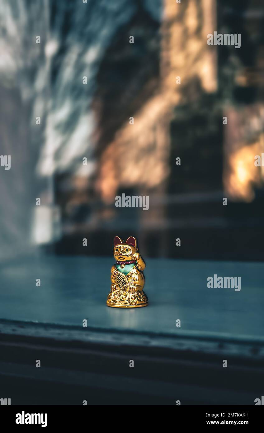 A small Japanese Maneki-neko cat (beckoning cat) that brings luck put ...