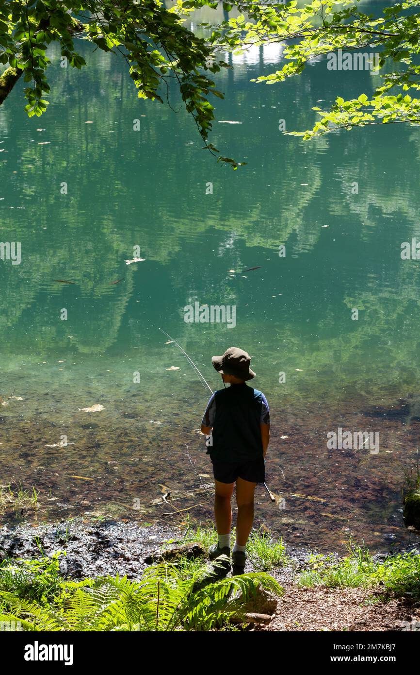Unrecognizable fisherman catching fish from the mountain lake in ...