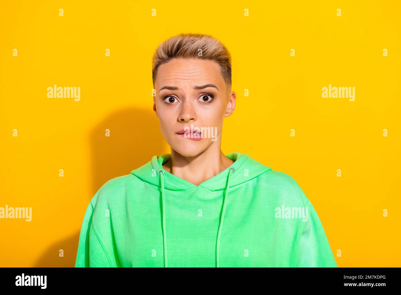 Photo of scared nervous young pretty girl biting lips staring isolated ...