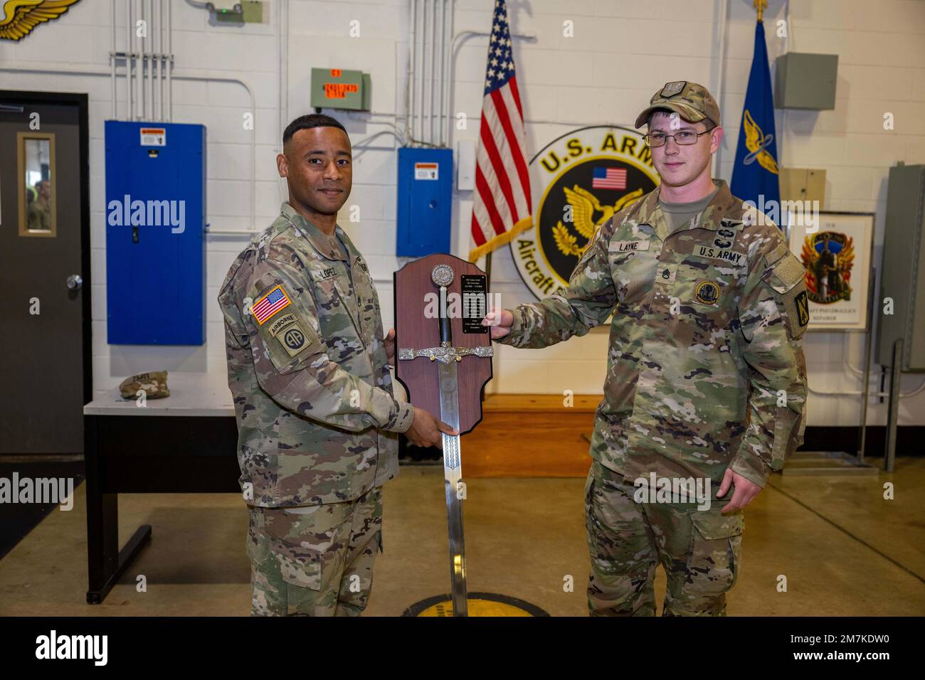 Staff Sgt. Joshua Layne presents Staff Sgt. Israel Lopez with a sword ...