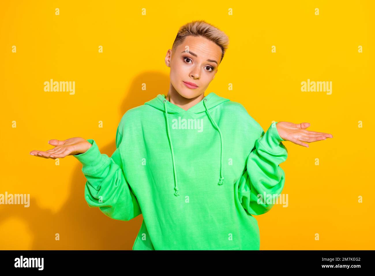 Photo of clueless young lady raise arms palms shrug shoulders dont know ...