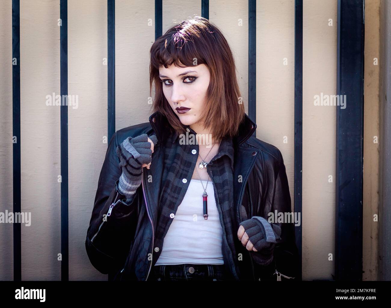 Young woman sitting down with a moody expression Stock Photo - Alamy