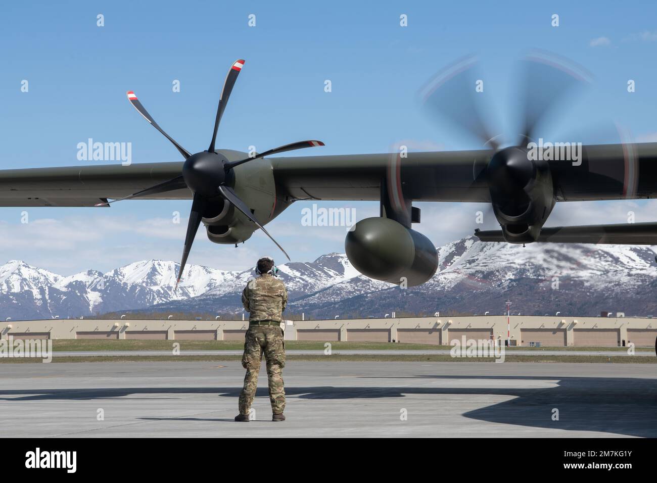 A Royal Air Force mechanic watches an engine start on a RAF C-130J ...