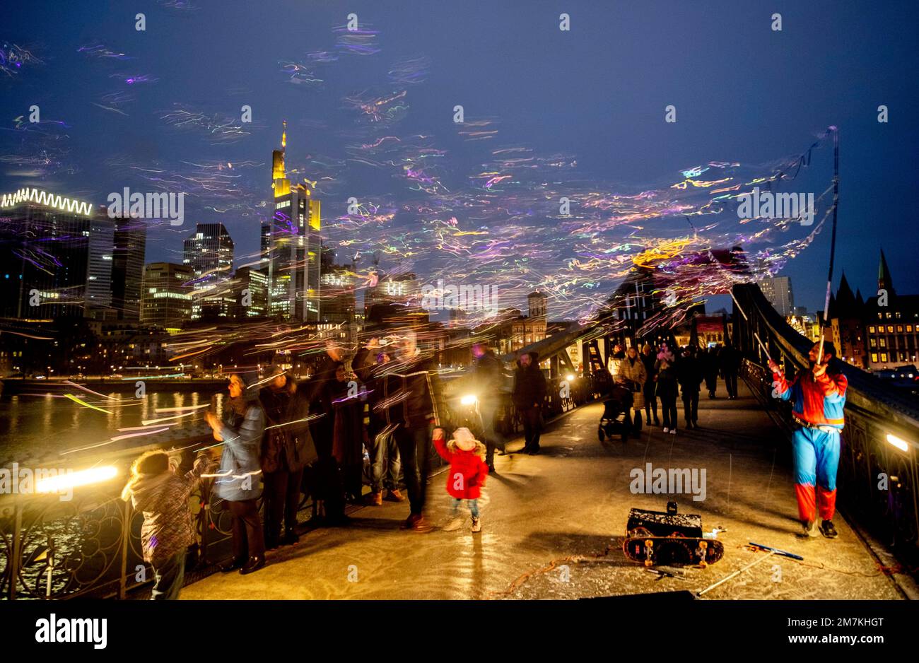 A man makes bubbles on a pedestrian bridge over the river Main in ...