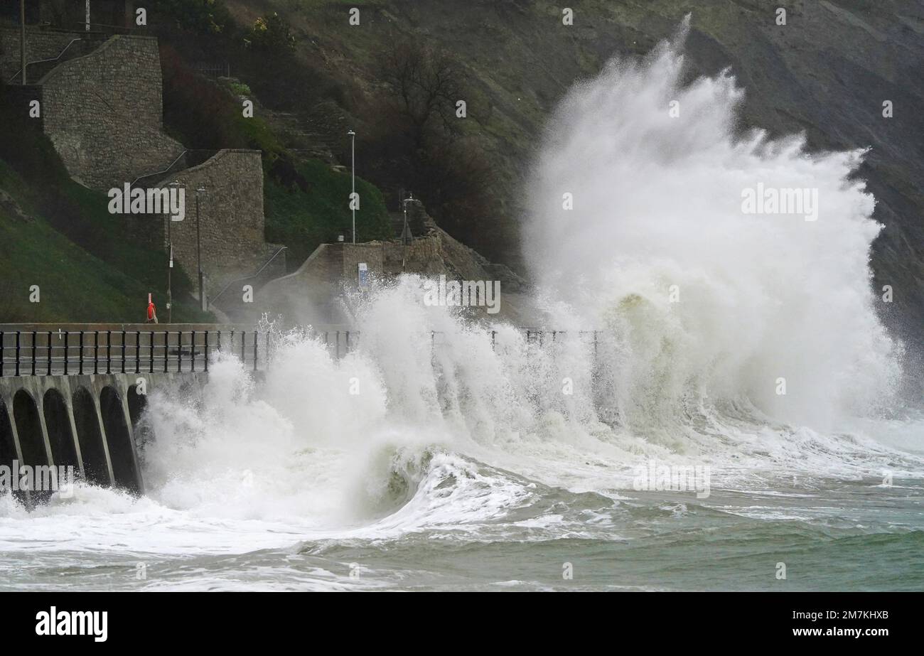 Waves crash over the promenade during rain and strong winds in ...