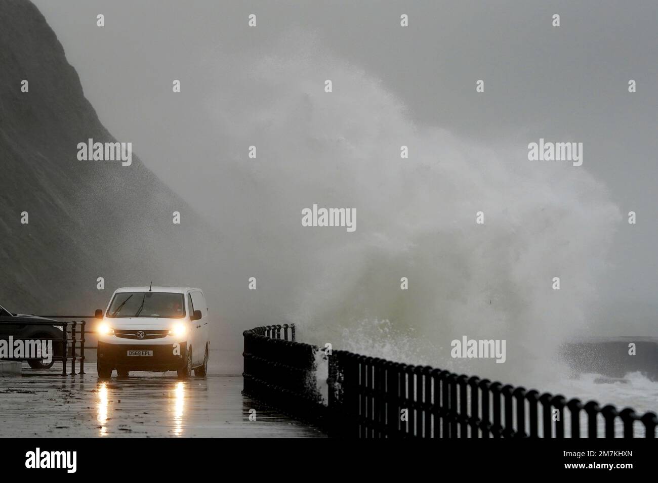 Waves crash over the promenade during rain and strong winds in ...