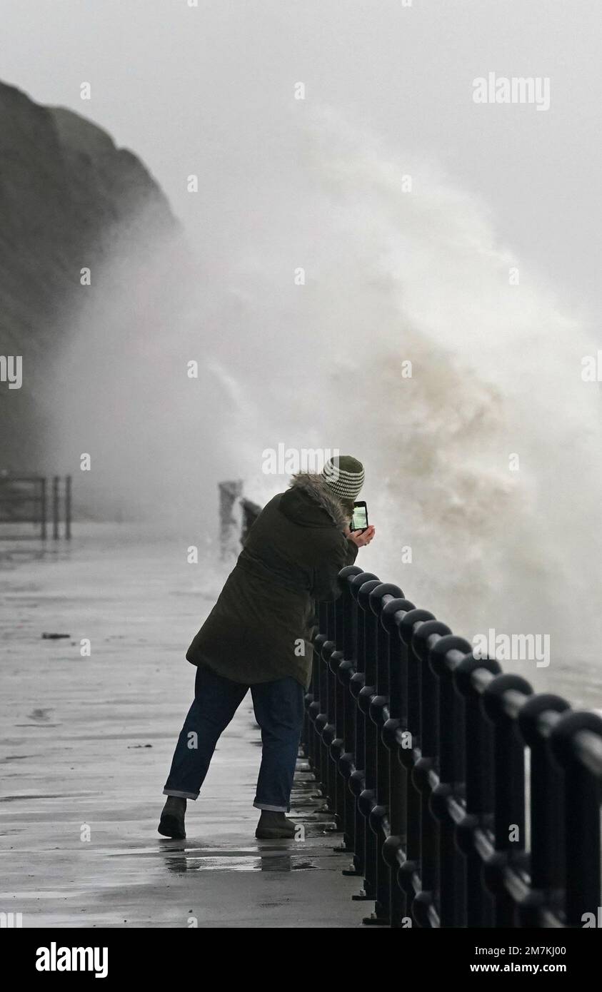 Waves crash over the promenade during rain and strong winds in ...