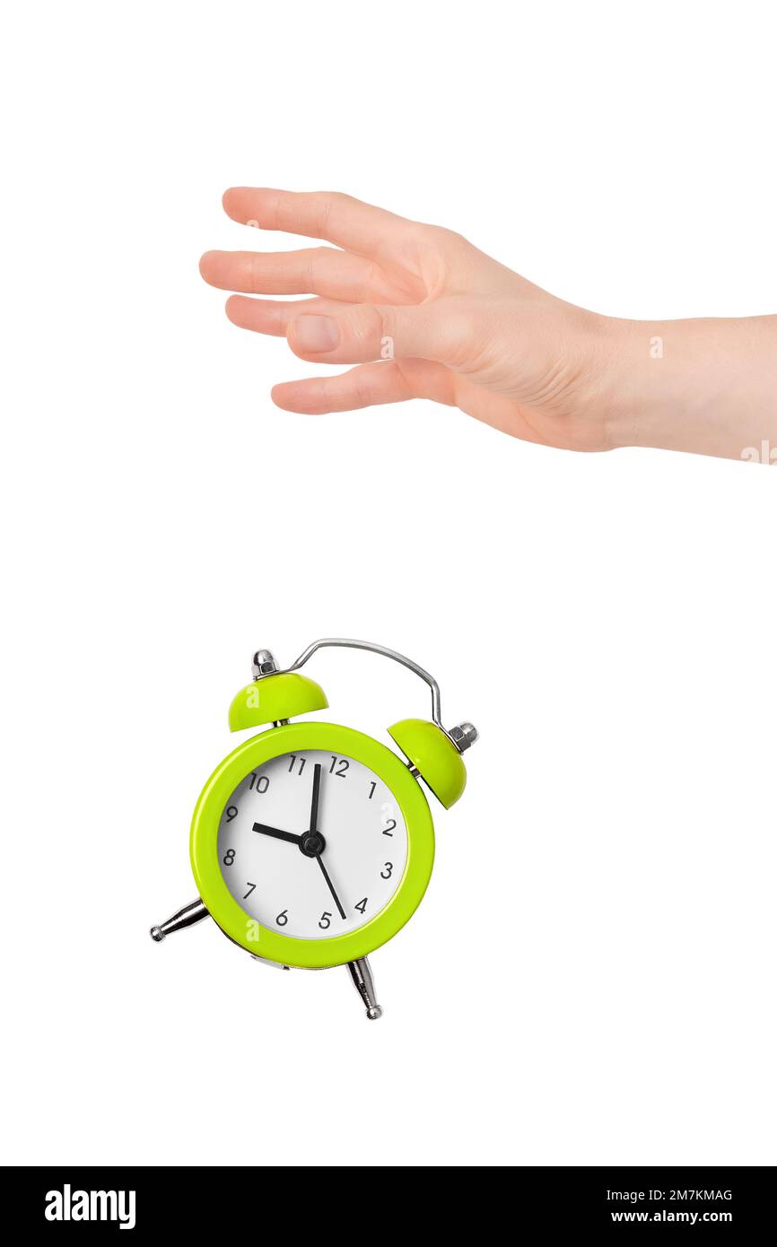 Hand dropping lime green metal alarm clock isolated on white background ...