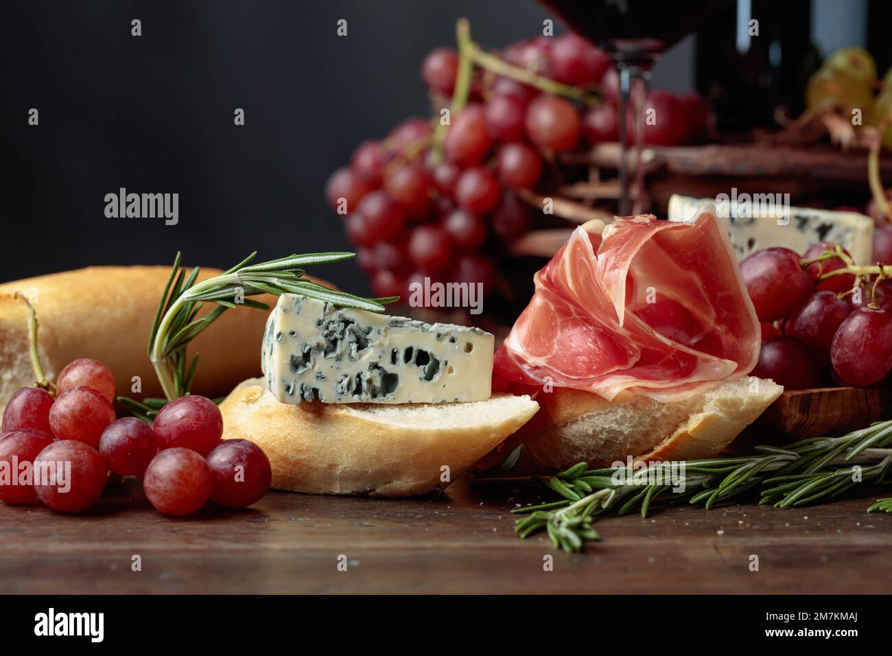 Sandwich with prosciutto, blue cheese and rosemary on a dark background ...