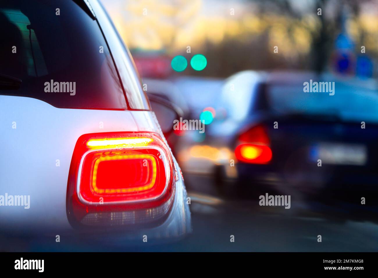 Car tail lights on city street in the evening at sunset time in winter ...