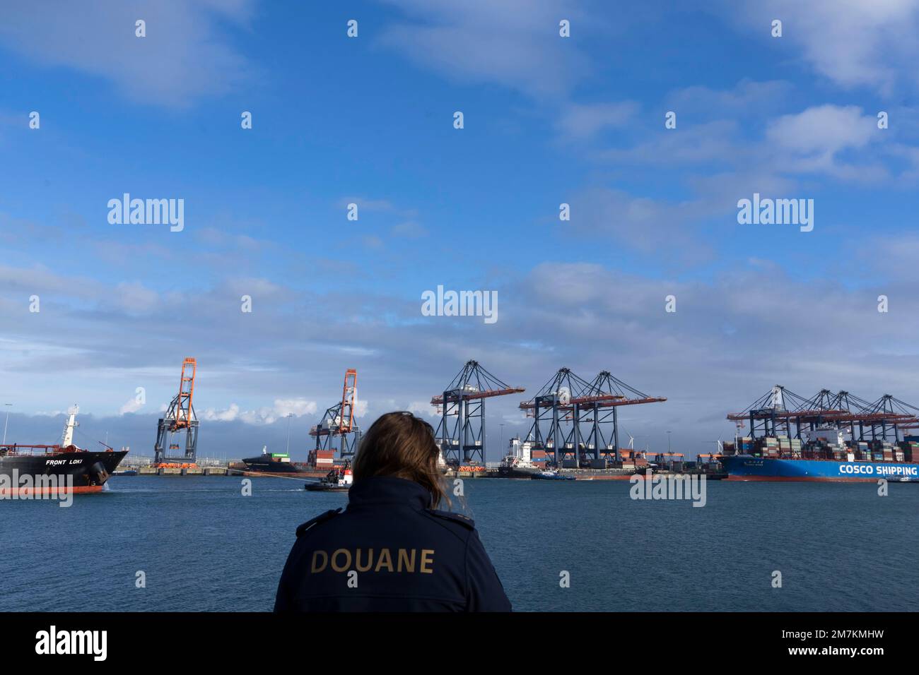 A Dutch customs officer poses for the media as containers are being ...