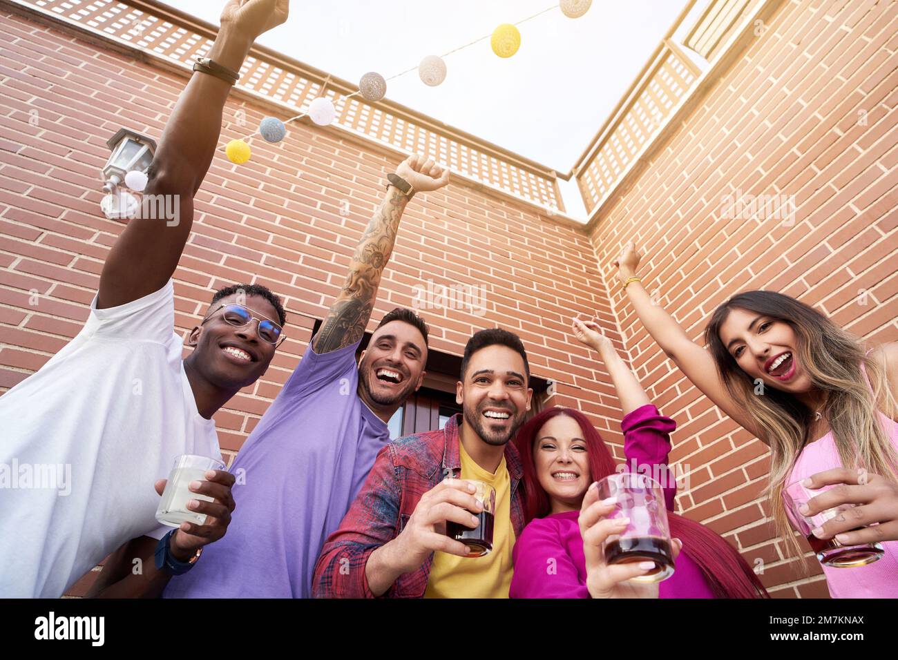 Excited friends celebrating and having fun while having a party ...