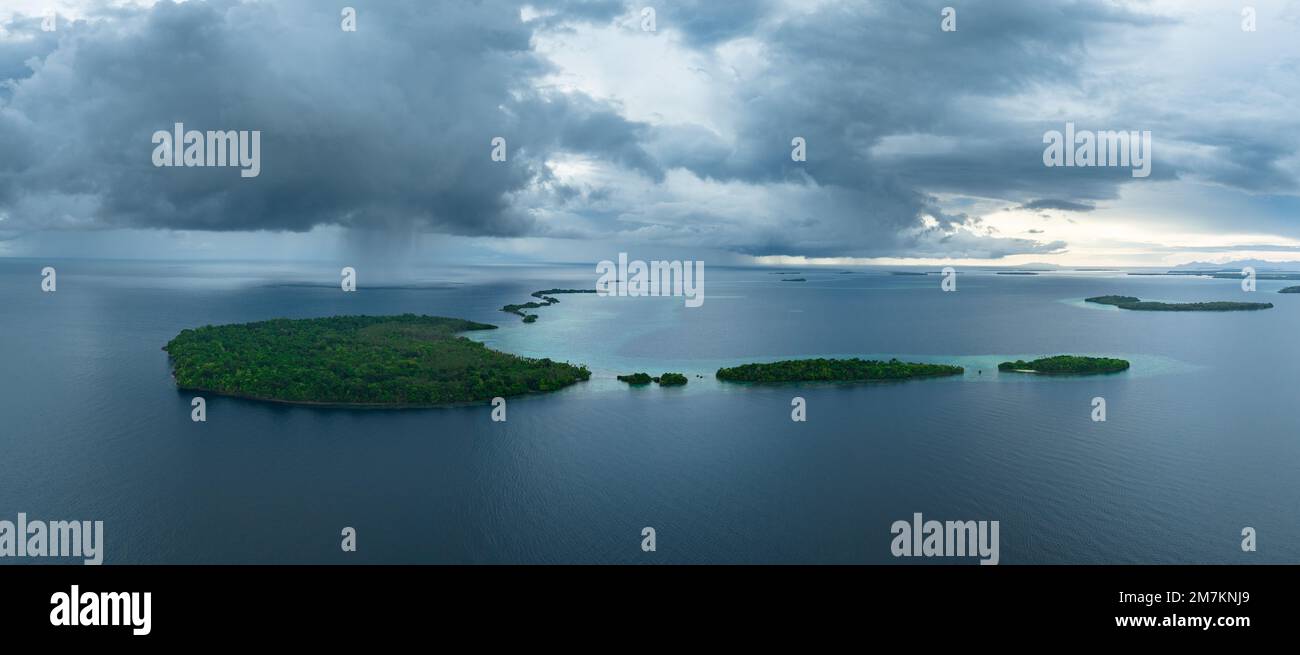 Storm clouds dump rain near a remote tropical island in the Solomon ...