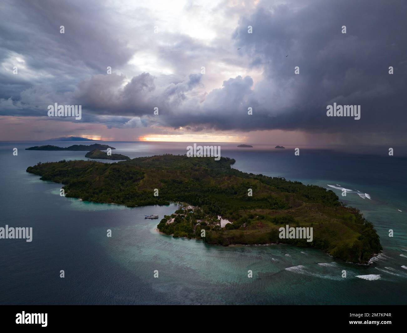 Storm clouds dump rain near a remote tropical island in the Solomon ...