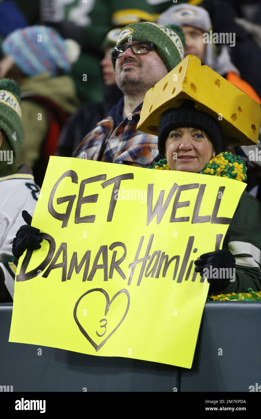 A Green Bay Packers fan holds a sign honoring injured Buffalo Bills ...
