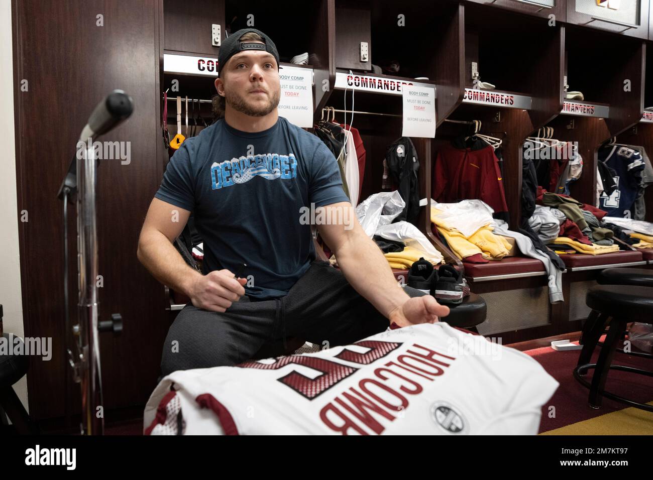 Washington Commanders linebacker Cole Holcomb, signs his jersey as he ...