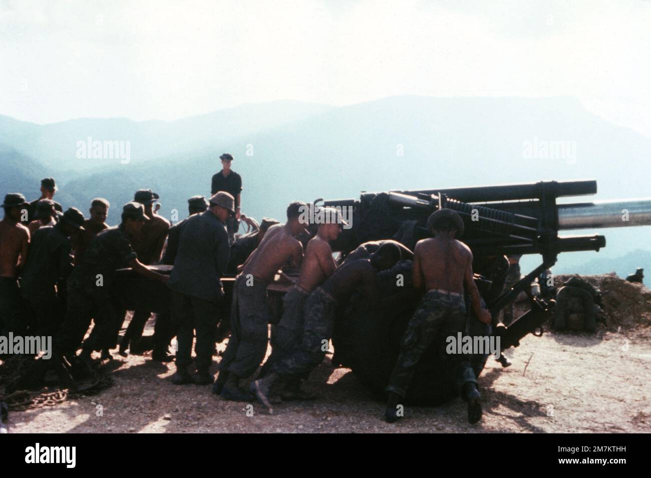 Members of the 3rd Marine Division move an M114 155 mm howitzer into position during ...