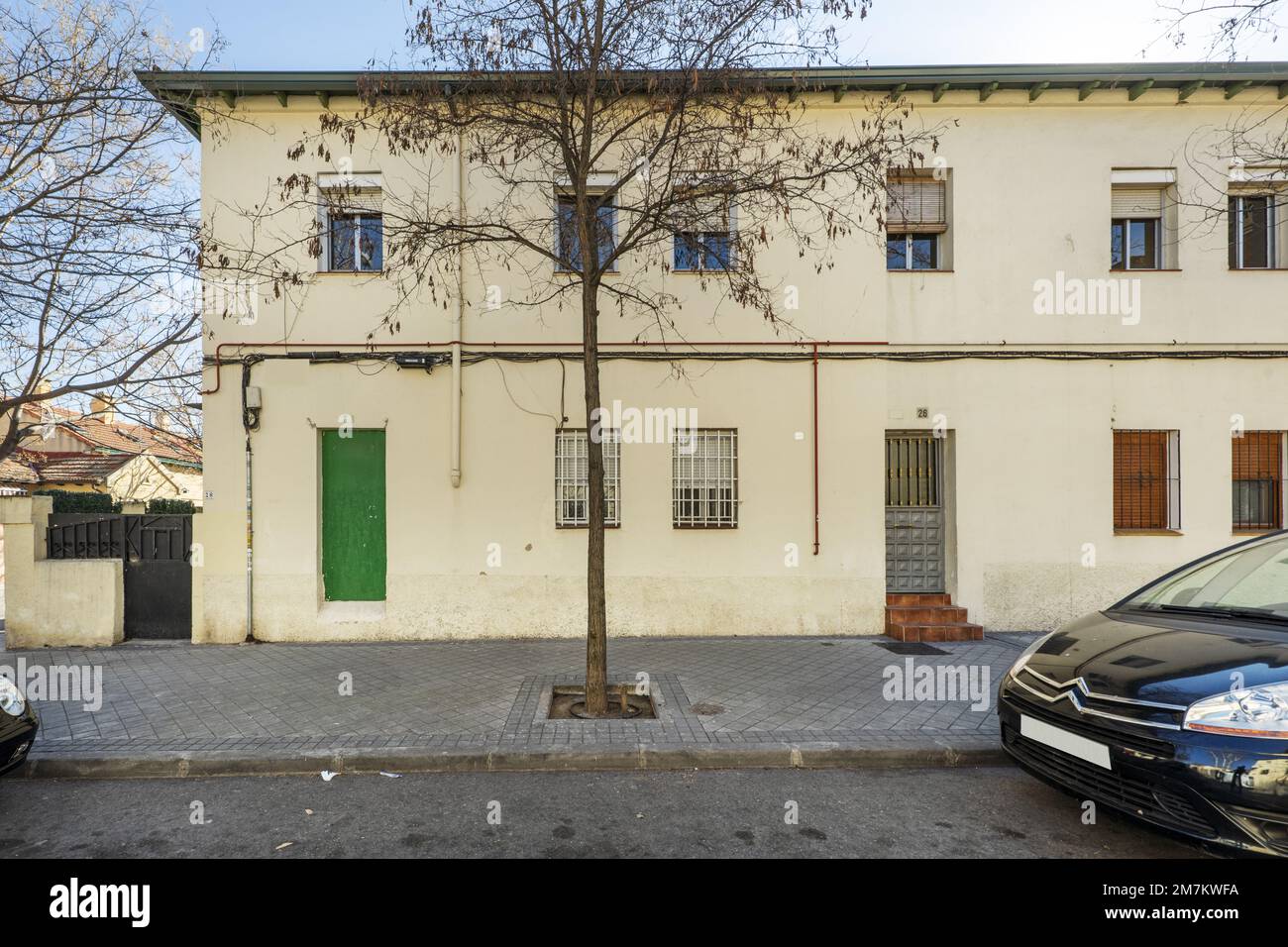 Facades of old low-rise residential houses with deciduous trees on a ...