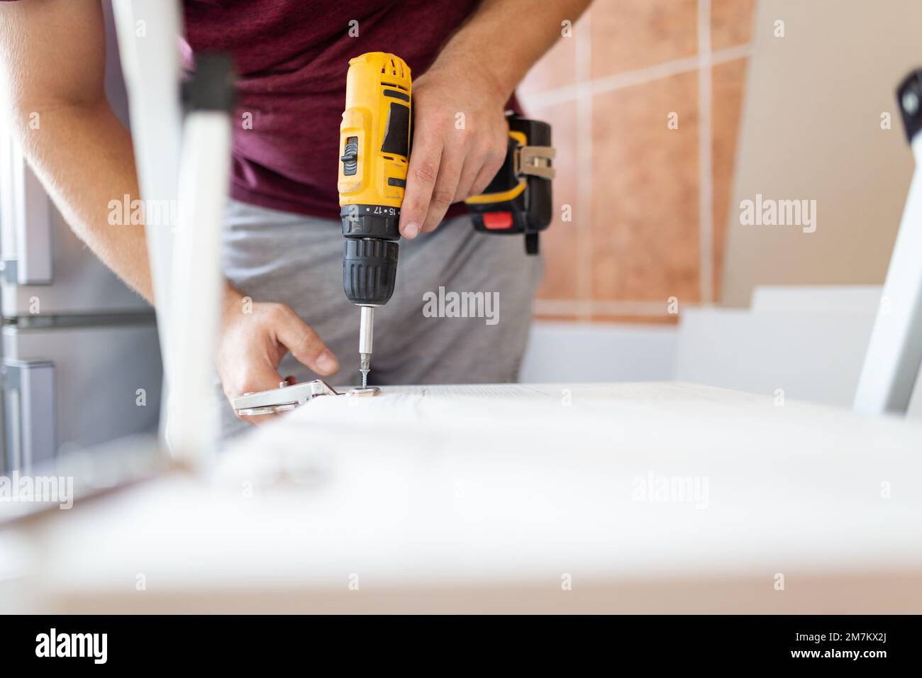 Screwing a self-tapping screw into a metal fastening hole on a wood ...