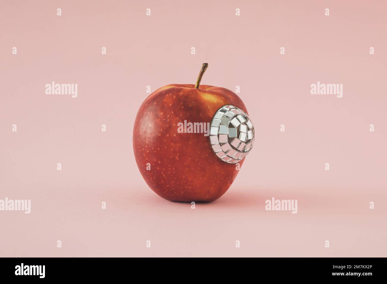 Fresh apple with disco ball on pink pastel background. Minimal fruit or ...