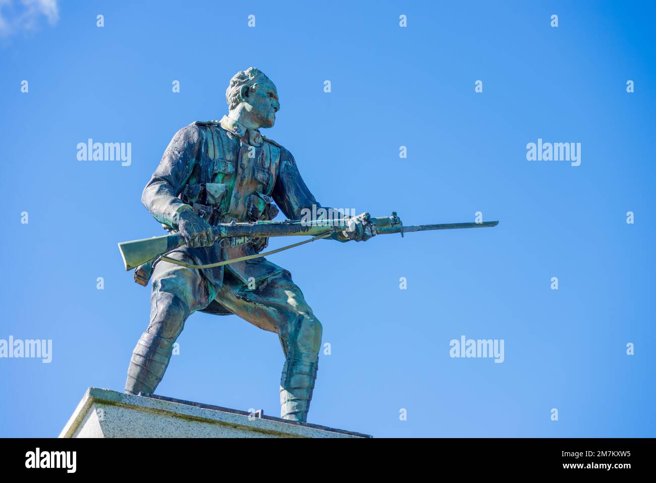The war memorial bronze statue of a soldier with a full kit holding a ...