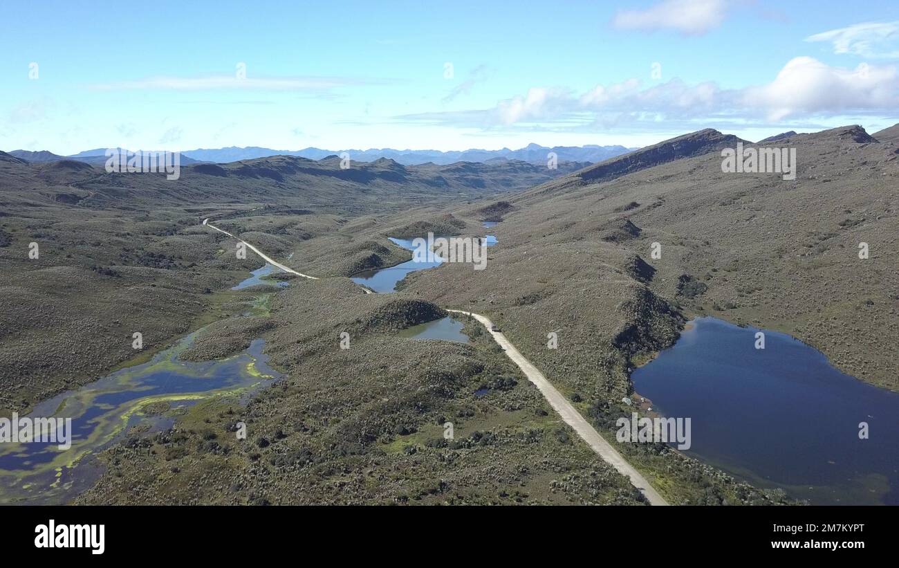 An aerial shot of a narrow countryside road surrounded by the big ...