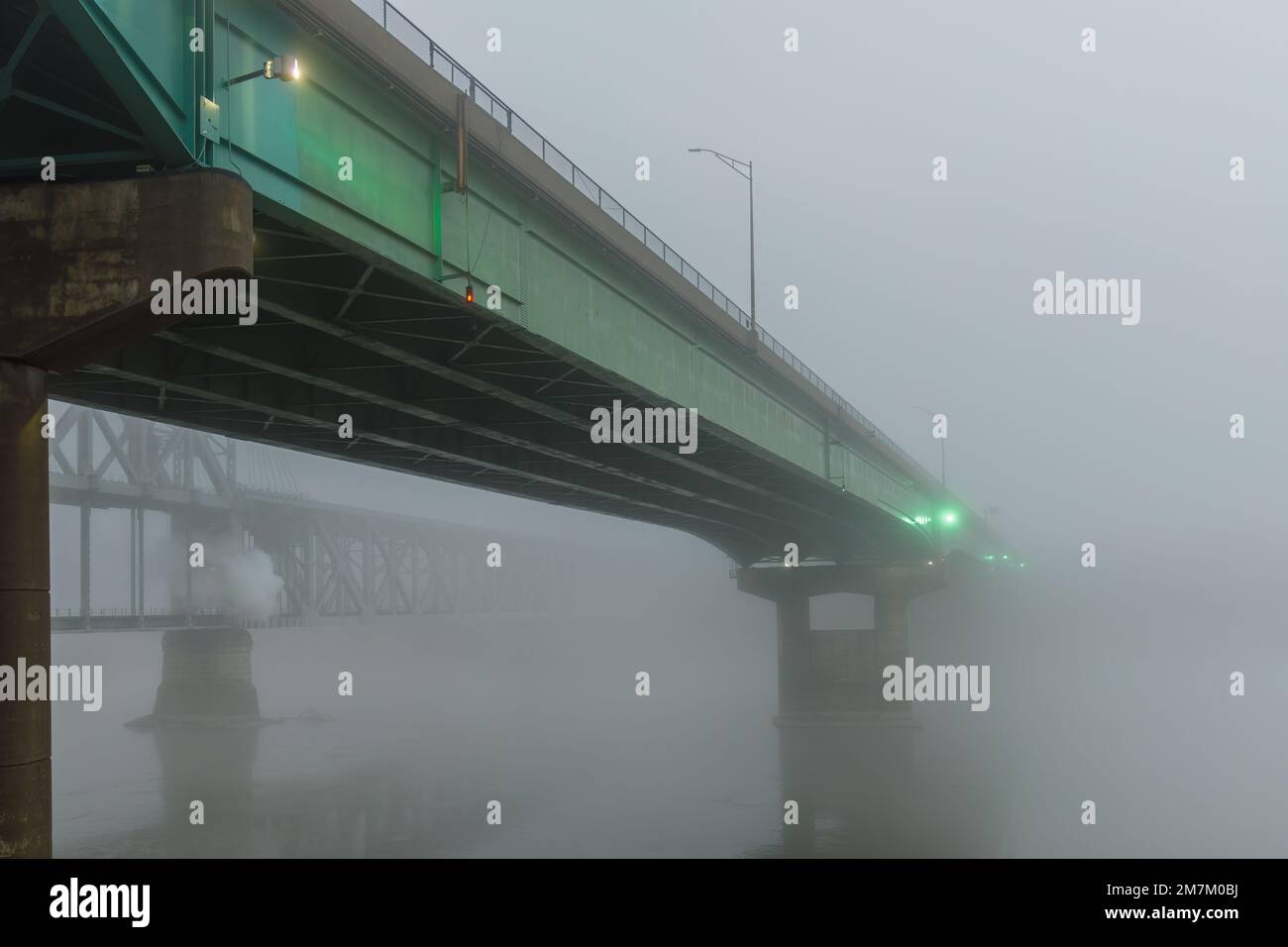 A road bridge fading into the heavy fog over the Missouri river Stock ...