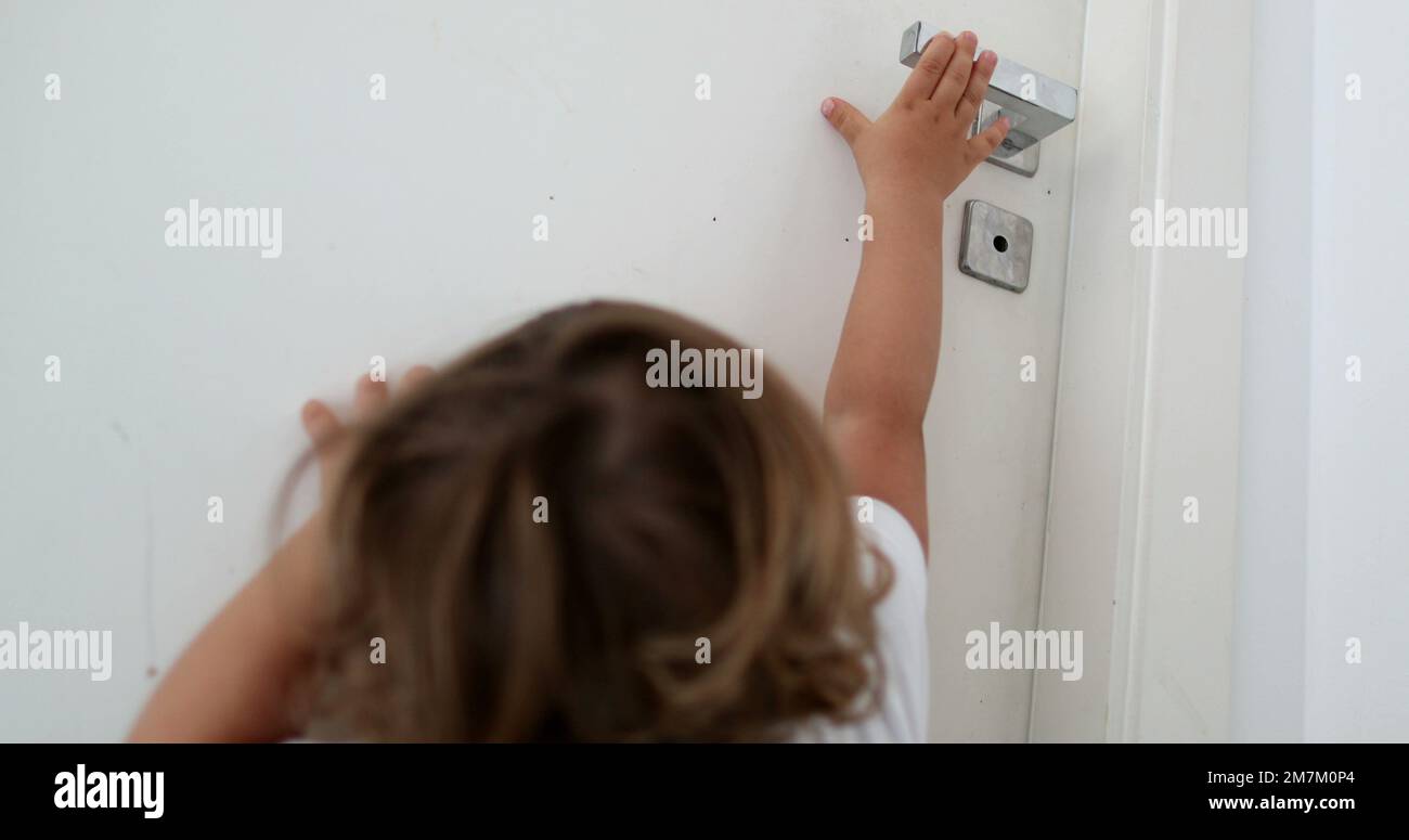 Baby trying to reach door knob. Child on tip toes reaching for door2 ...