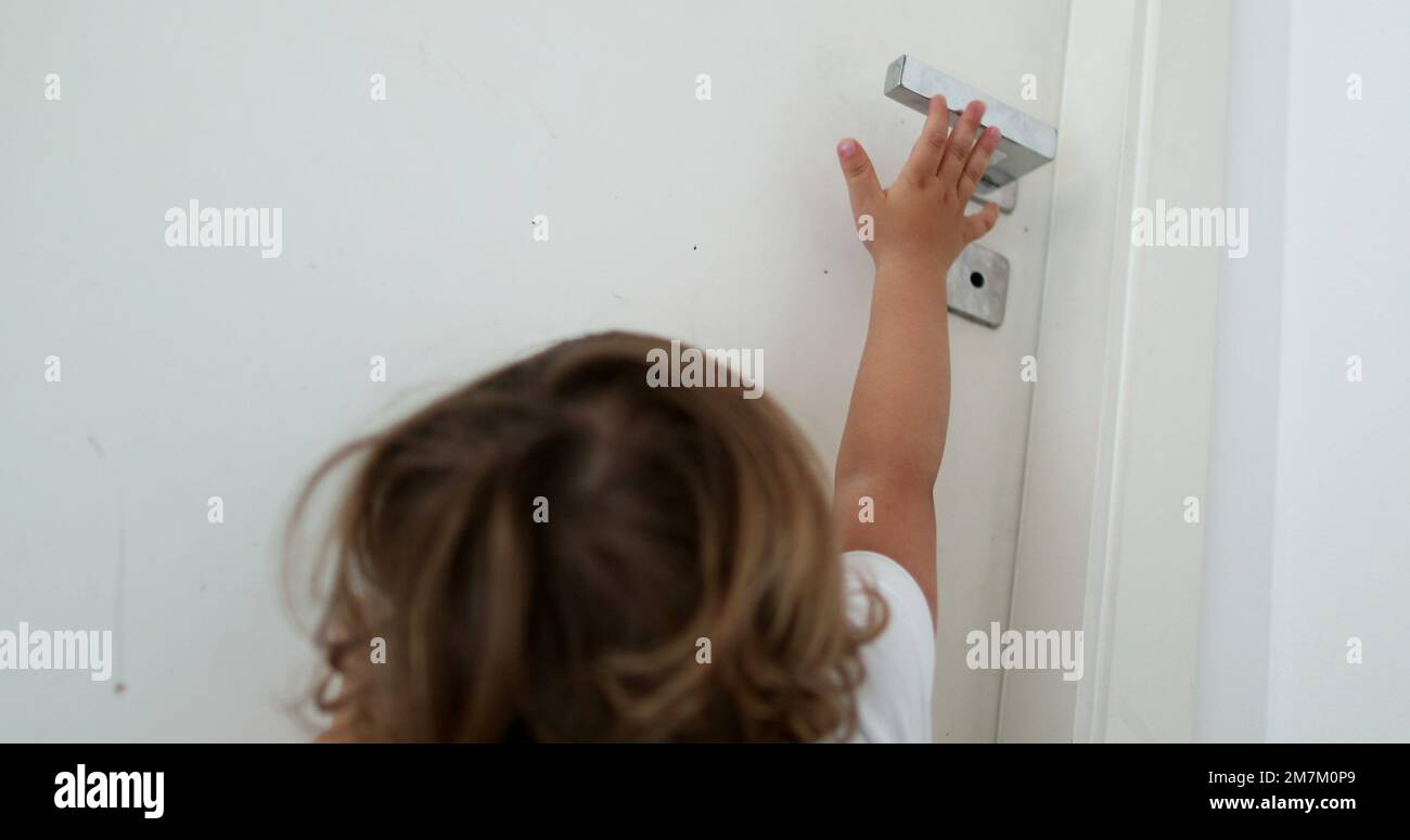 Baby trying to reach door knob. Child on tip toes reaching for door2 ...