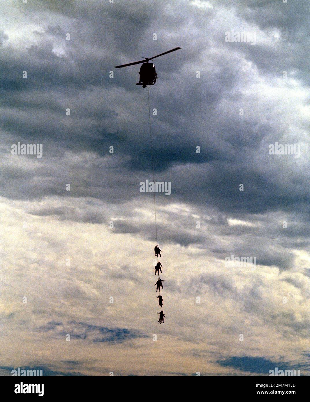 Ten Marine Corps test jumpers in "stick" formation are towed by a UH-1N ...