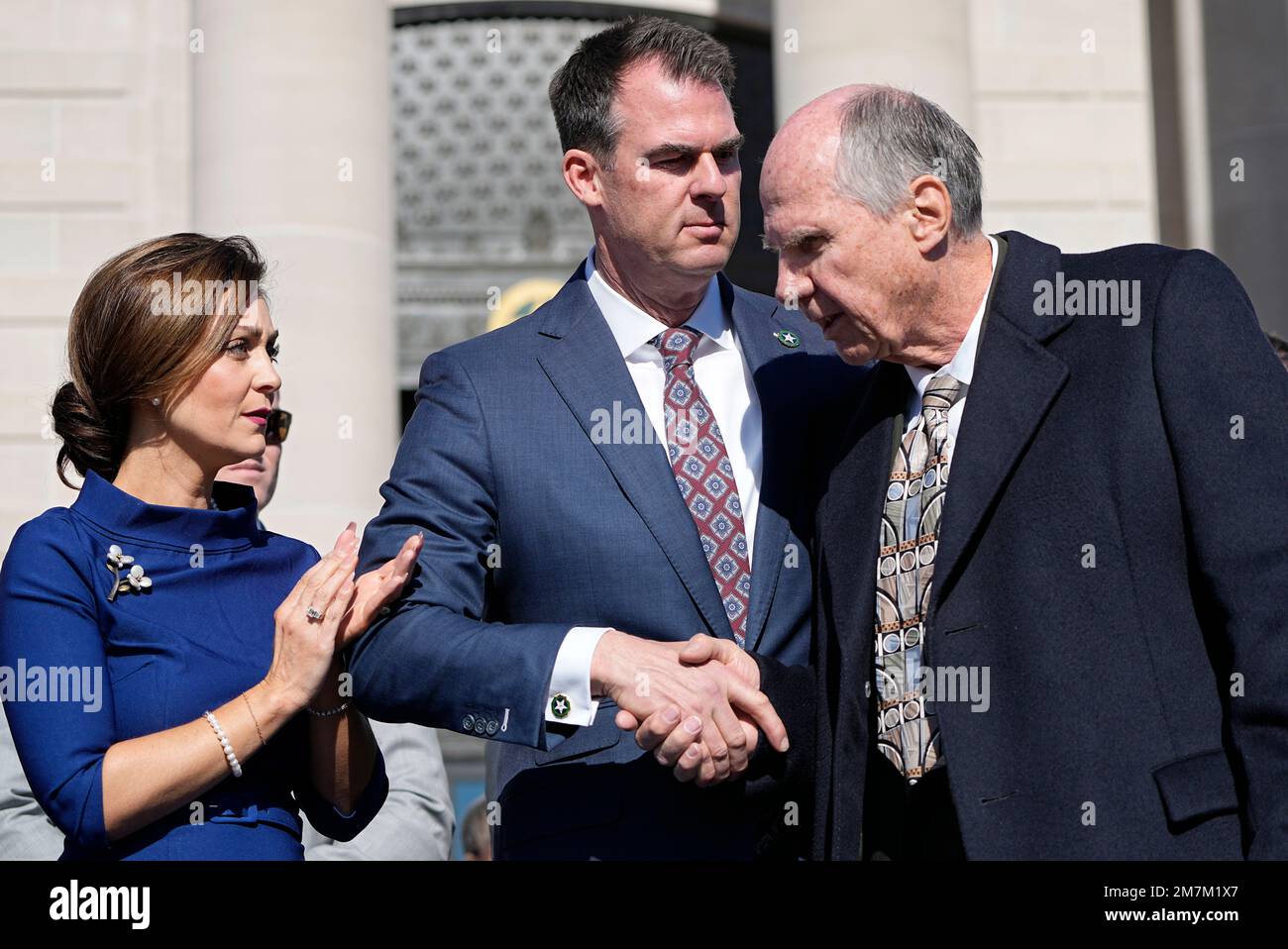 The Rev. John L. Stitt, right, shakes hands with his son, Oklahoma Gov ...