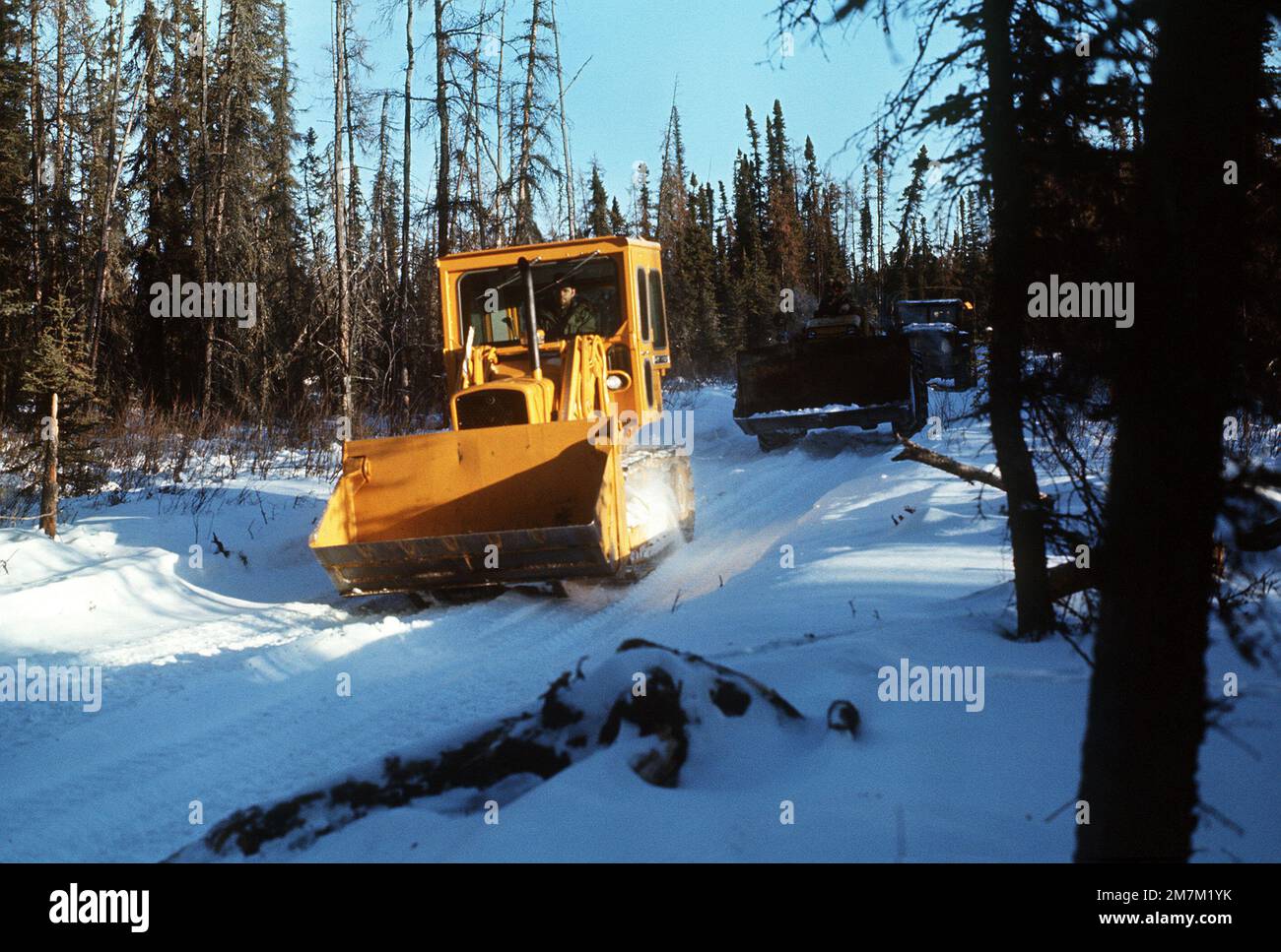 Front-end loaders move through the snow en route to Blair Lakes Range ...