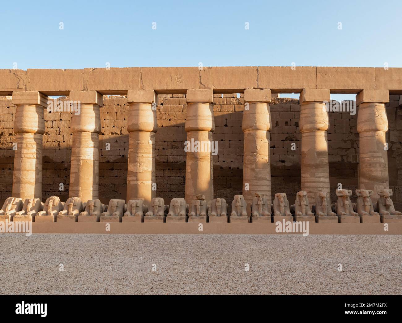 Columns and statues in the Temple of Karnak in Luxor with sunset ...