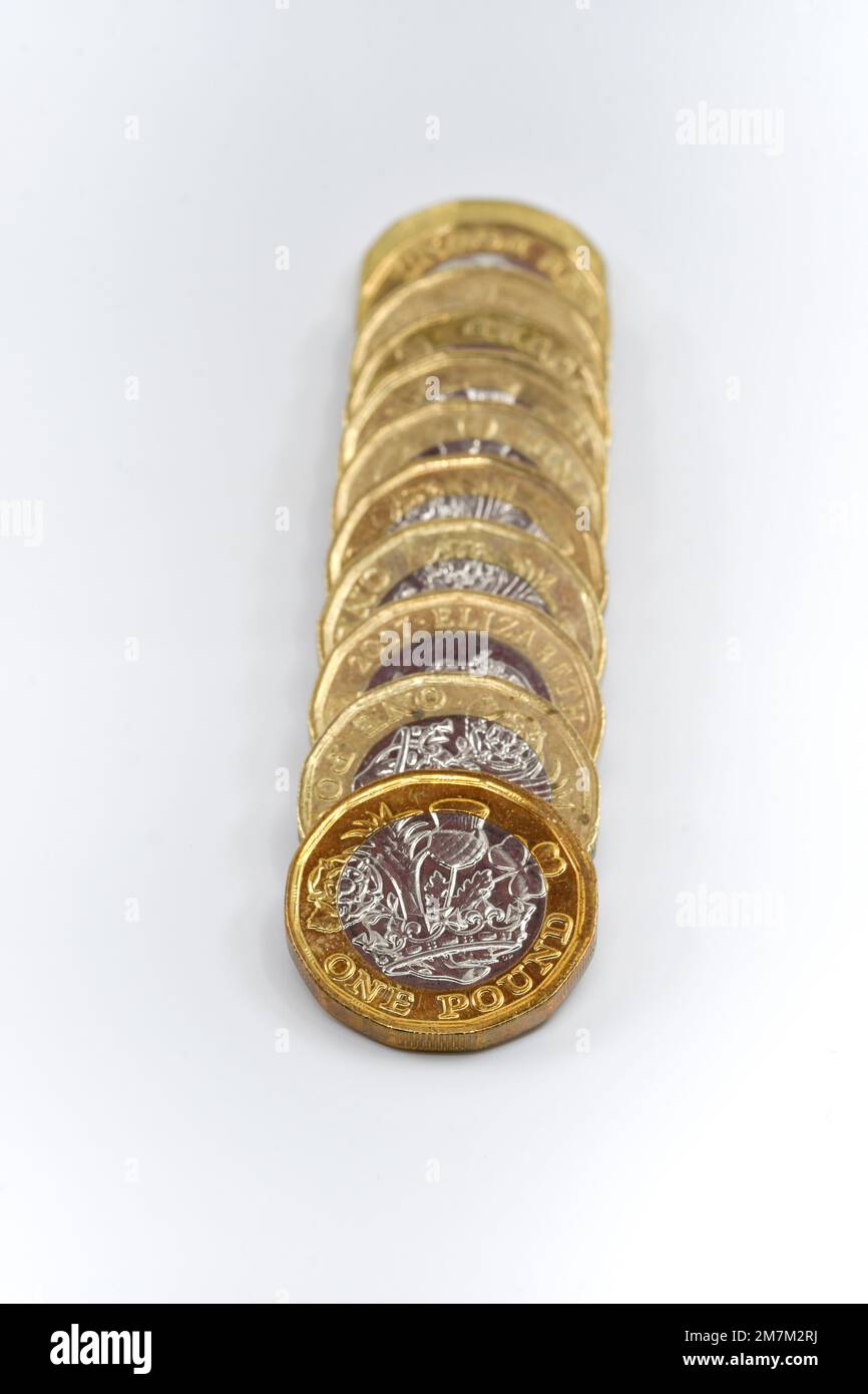 Close up view of a row of British One Pound coins isolated on a plain ...