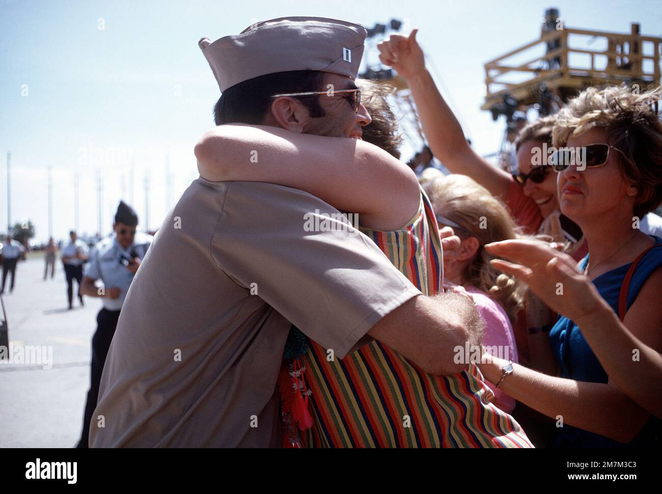 Unidentified ex-POW, U.S. Navy LT gets a hug from one of the many well ...