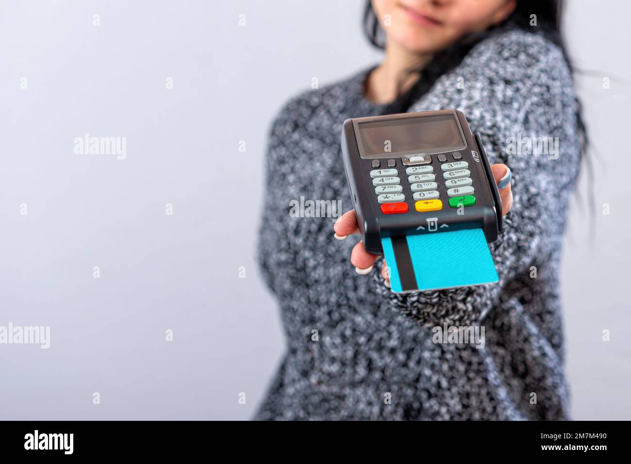 caucasian female holding payment terminal and giving it to the customer ...